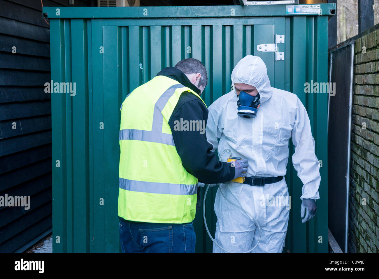 An environmental safety equipped worker in a paper body suit with ...