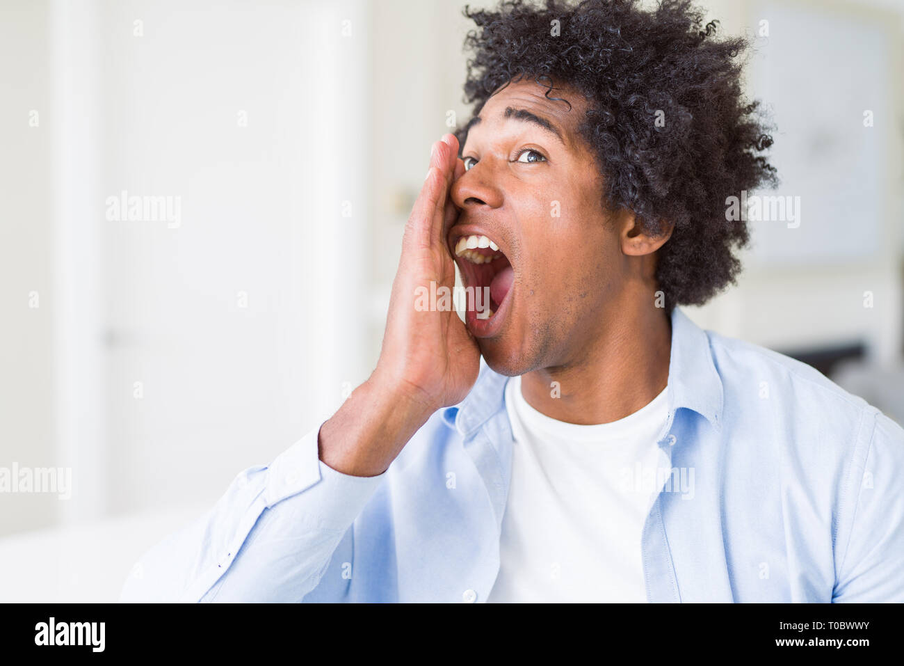 African American man at home shouting and screaming loud to side with ...