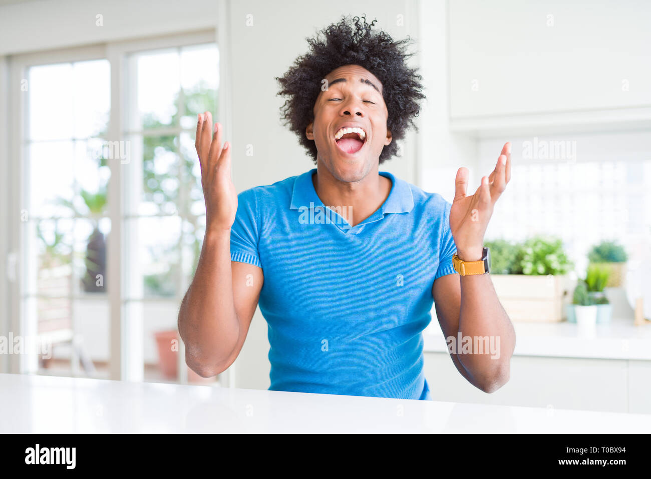 African American man at home celebrating mad and crazy for success with ...