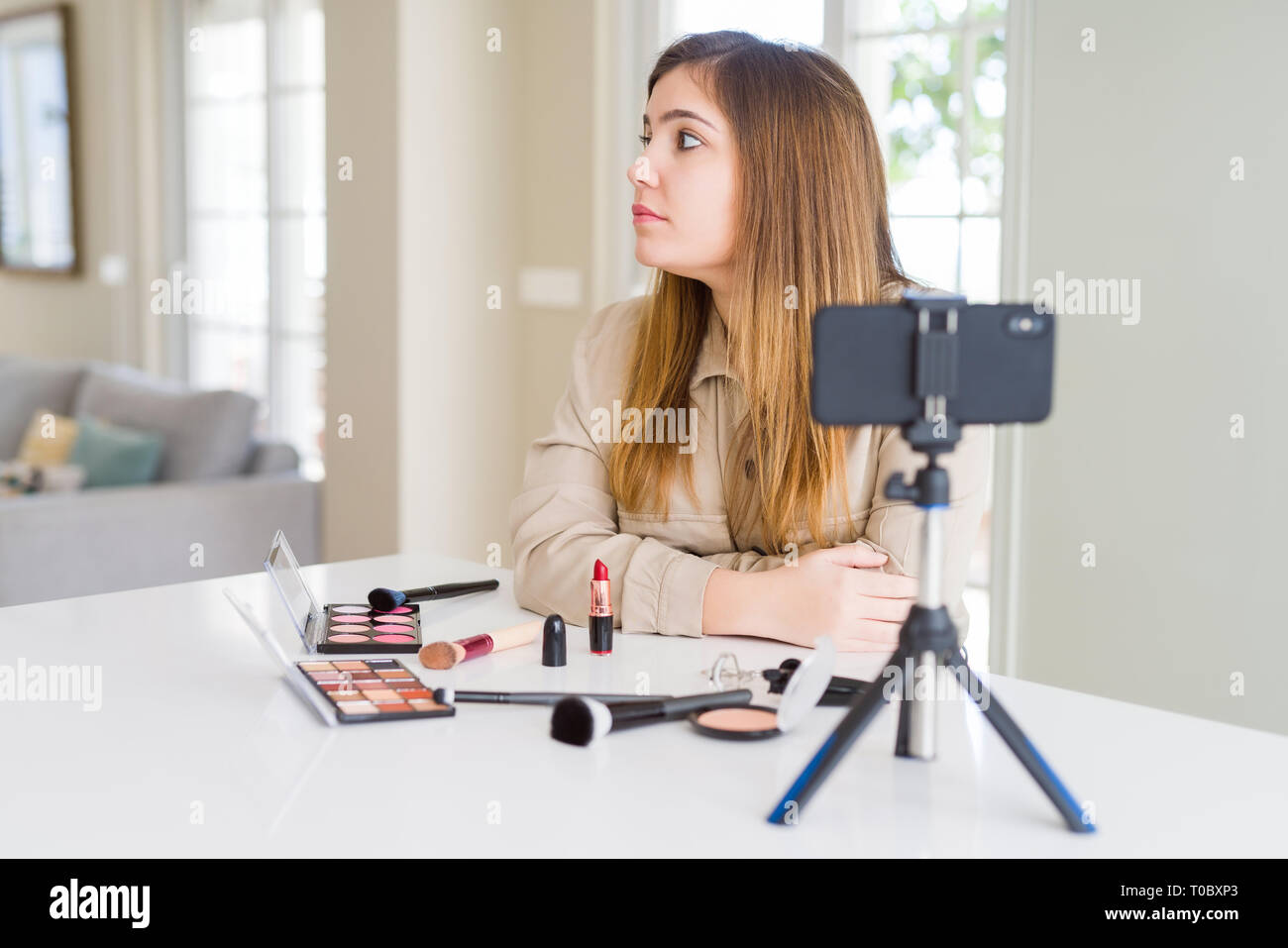 Beautiful young influencer woman recording make up video tutorial ...