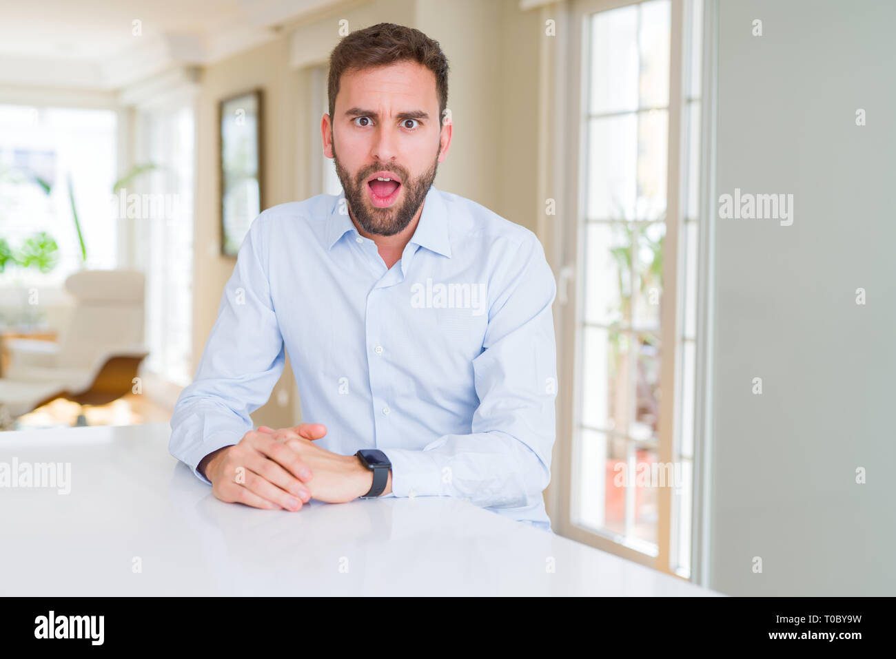 Handsome business man afraid and shocked with surprise expression, fear ...