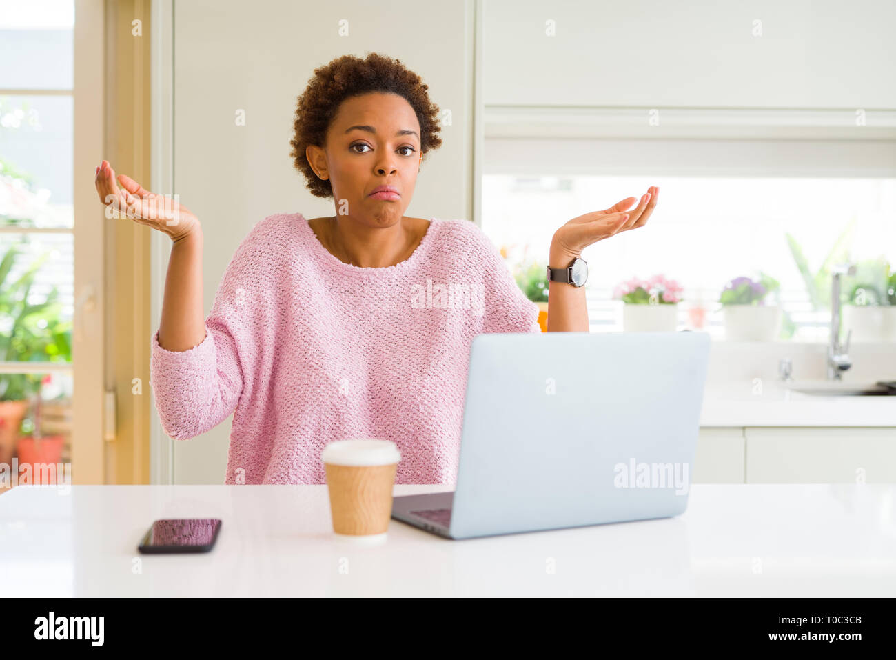 Young african american woman working using computer laptop clueless and ...