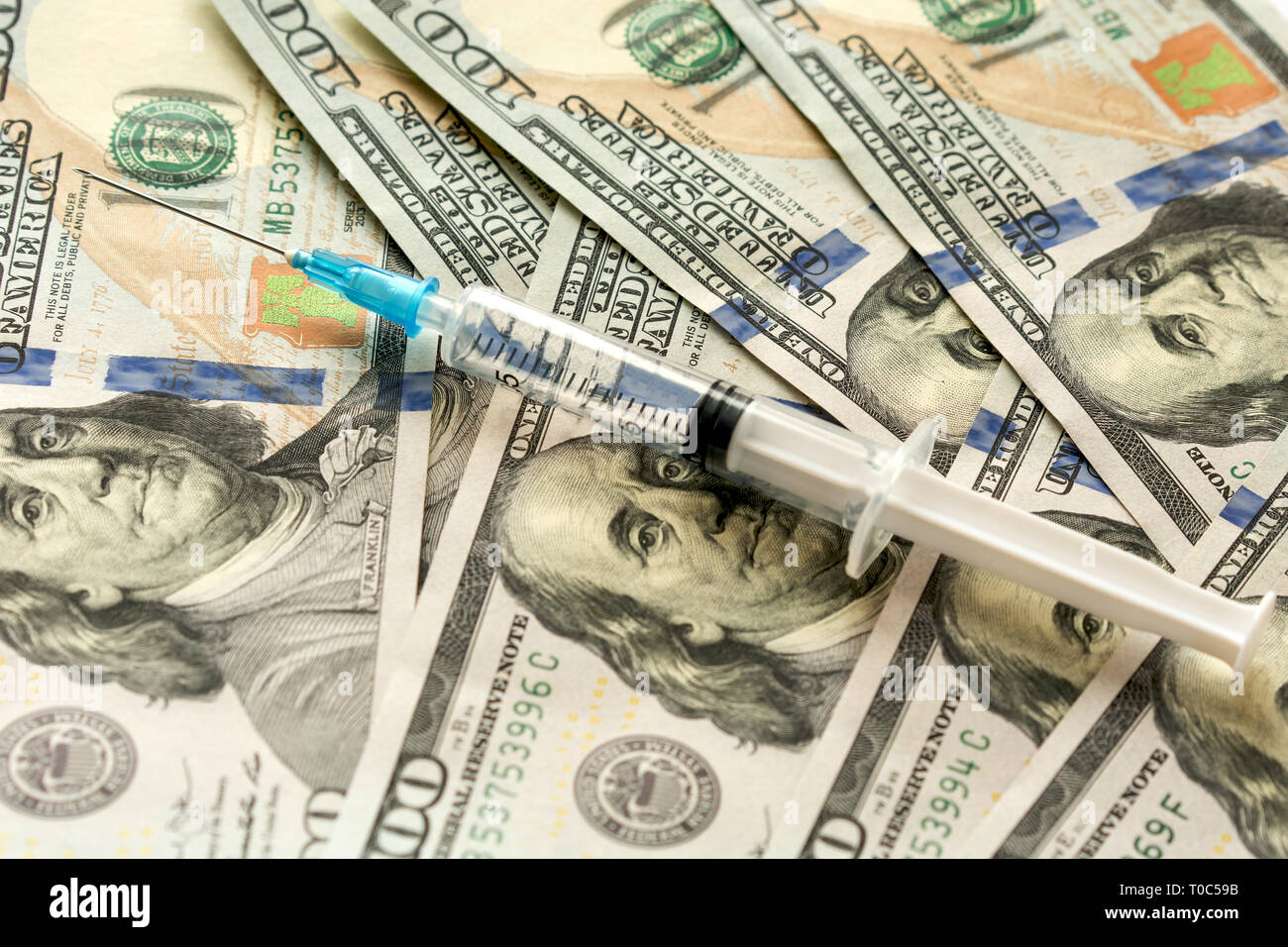 close up of syringe with injection on dollar banknotes Stock Photo - Alamy