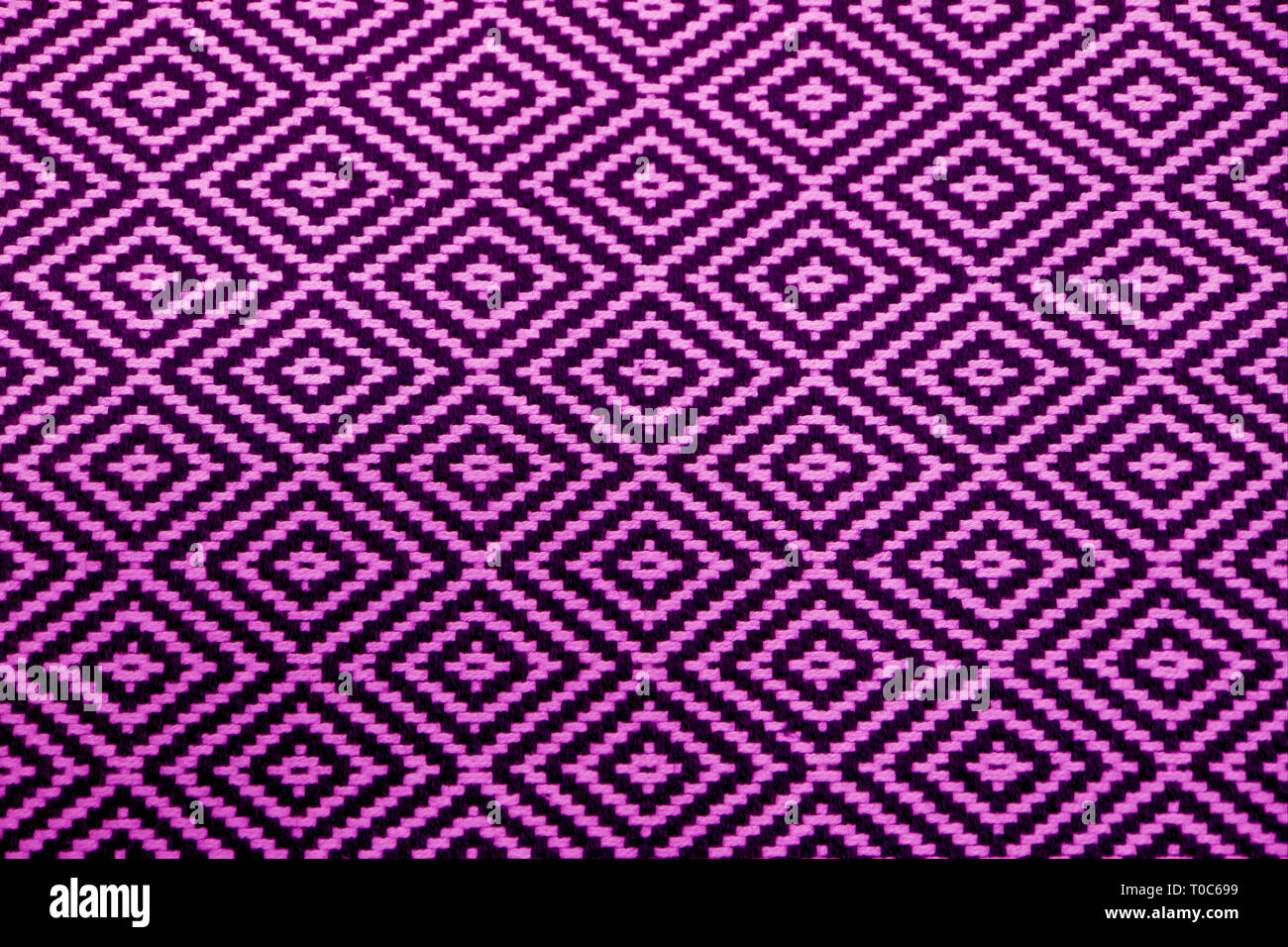 Front view of vibrant purple and black ethnic pattern fabric for ...