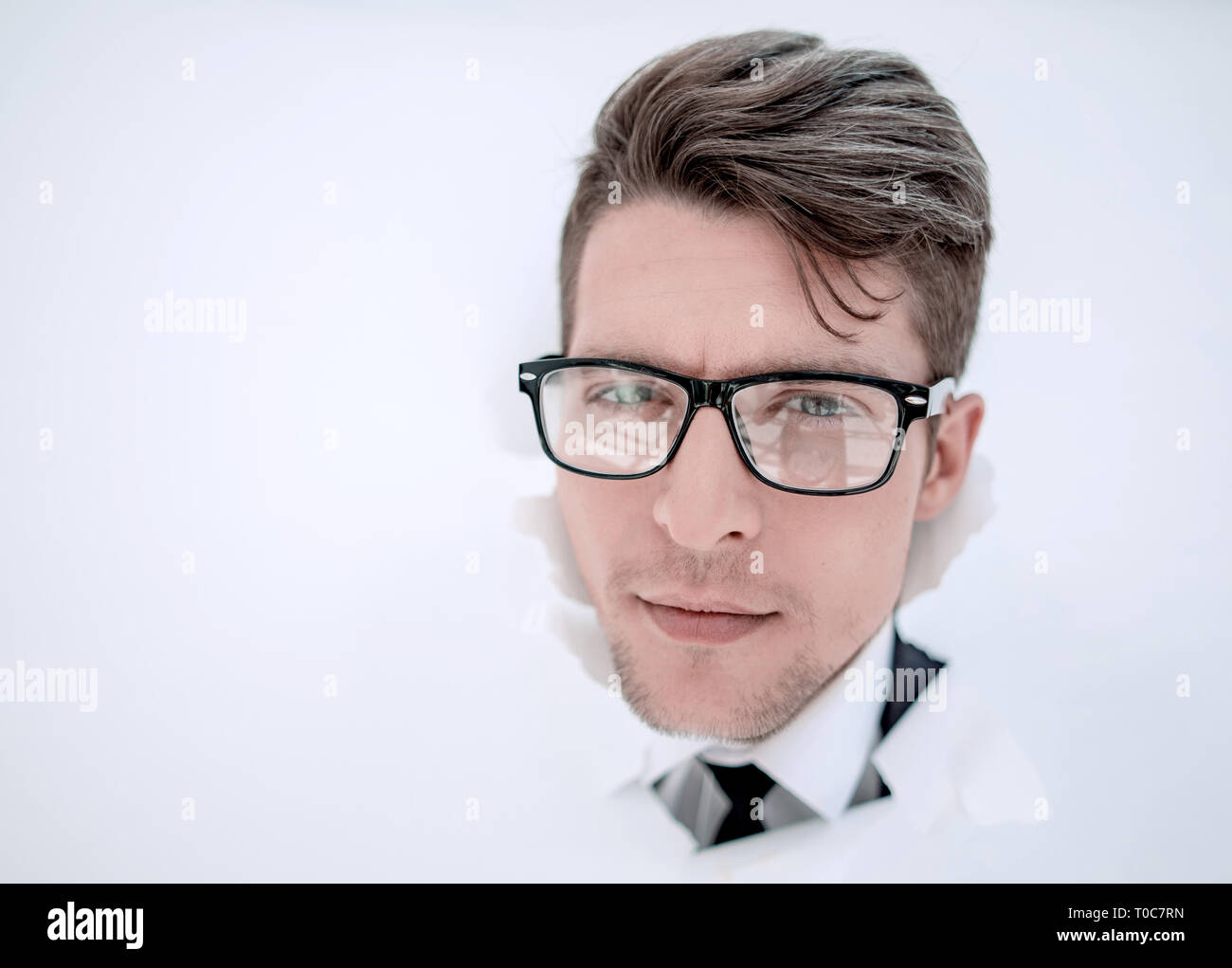young businessman breaking through a paper wall Stock Photo - Alamy