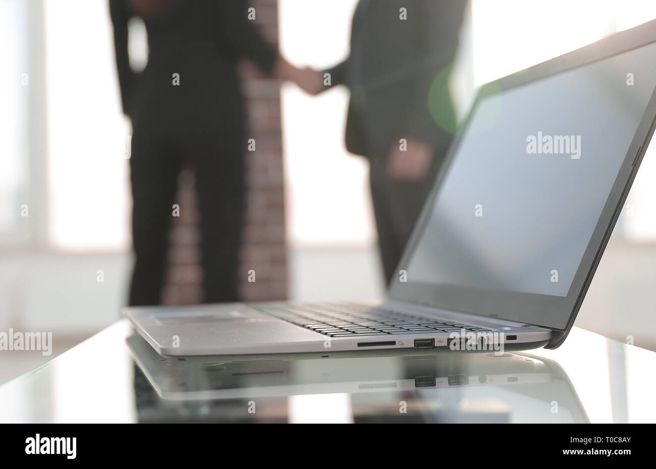laptop on the desk, background handshake Stock Photo - Alamy