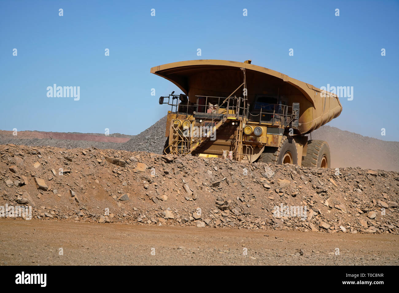 Gold mine operation in open gold mine pit with large haul truck leaving ...