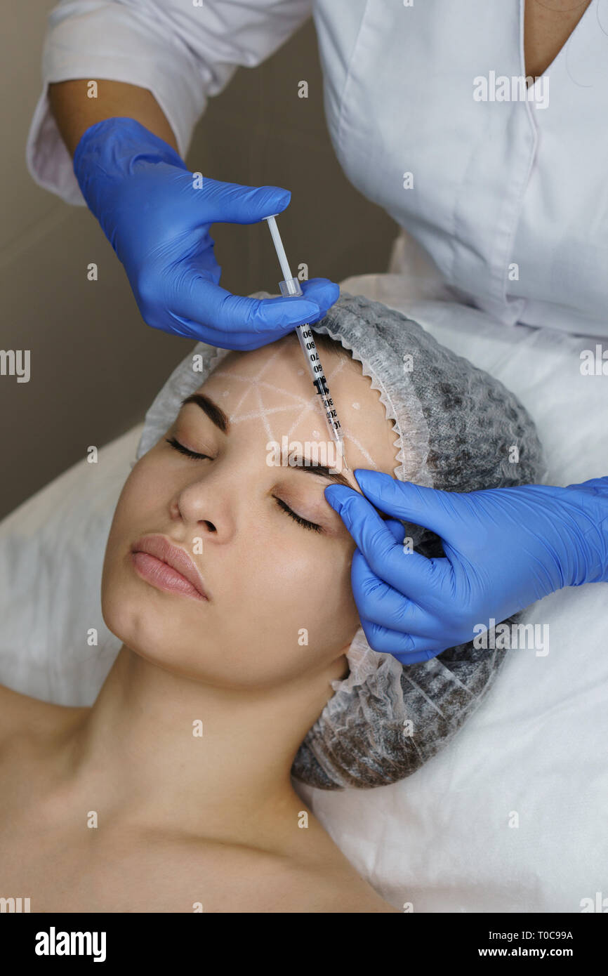 Aesthetic cosmetology. Facelift in spa salon. Beautician doing ...