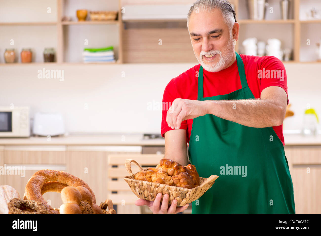 Old male baker working in the kitchen Stock Photo - Alamy