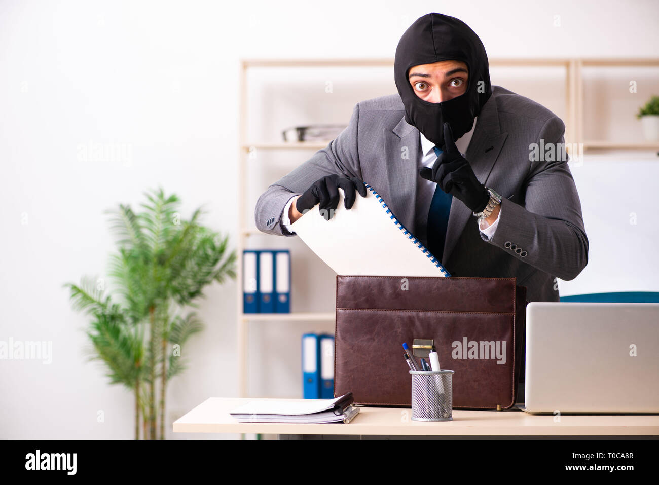 Male gangster stealing information from the office Stock Photo - Alamy