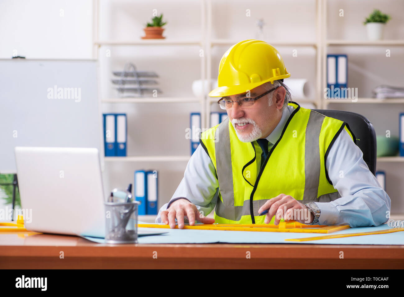 Aged construction engineer working in the office Stock Photo - Alamy