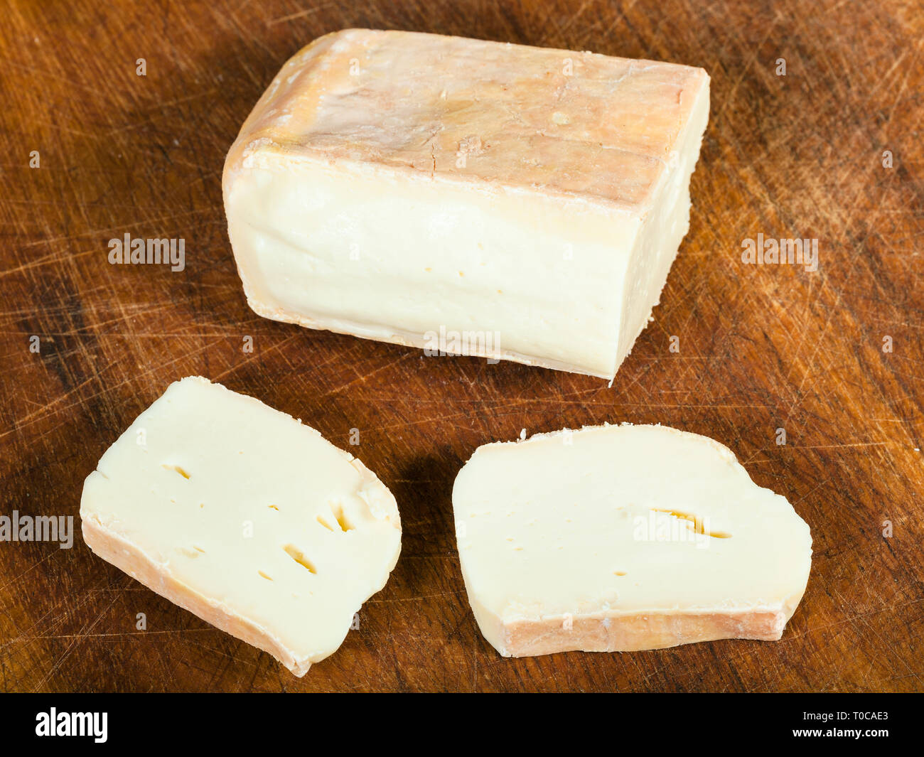 sliced local italian Taleggio cheese from cow's full milk on dark ...