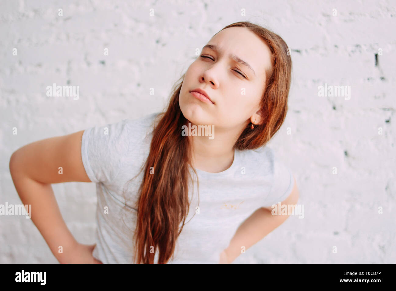 Suspicious teen girl squinted her eyes and looks at the camera isolated ...