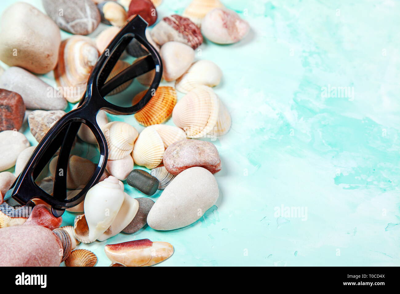 summer card with pebbles, shells and glasses Stock Photo - Alamy