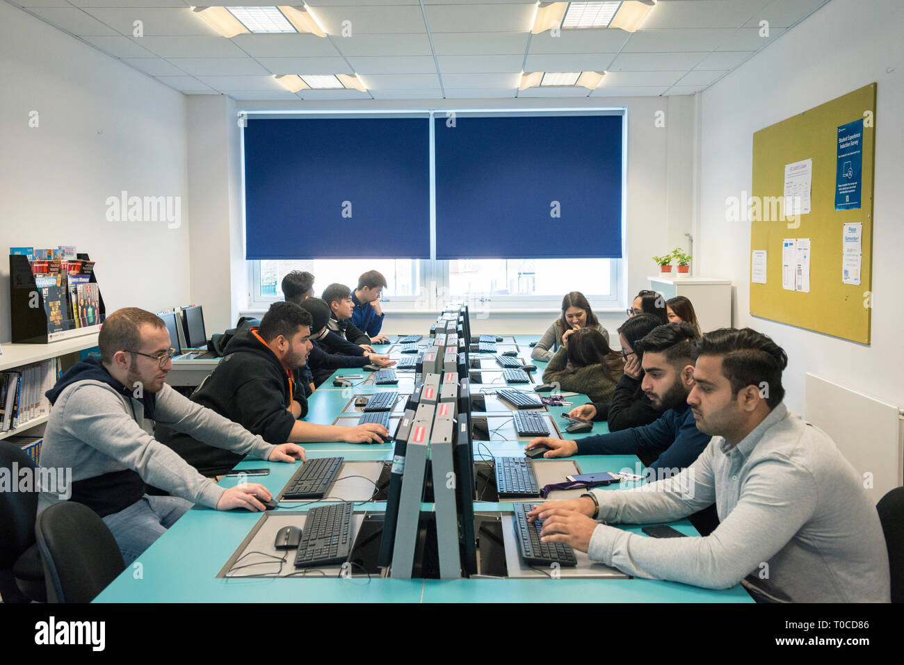 international students and pupils in the computer room of a college ...