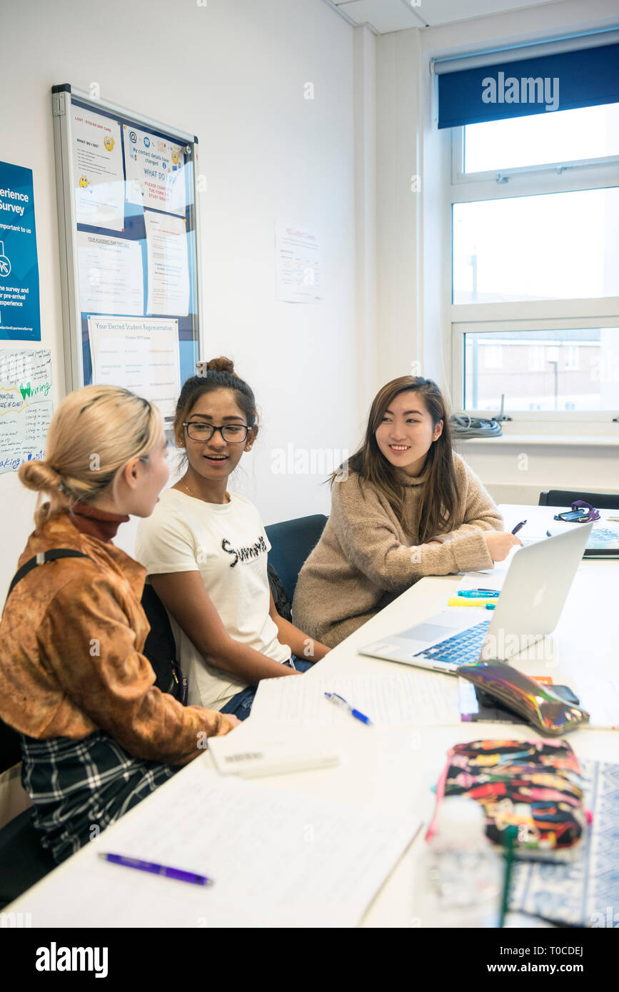 pupils and students in a classroom at a college / university, being taught a lesson while in ...