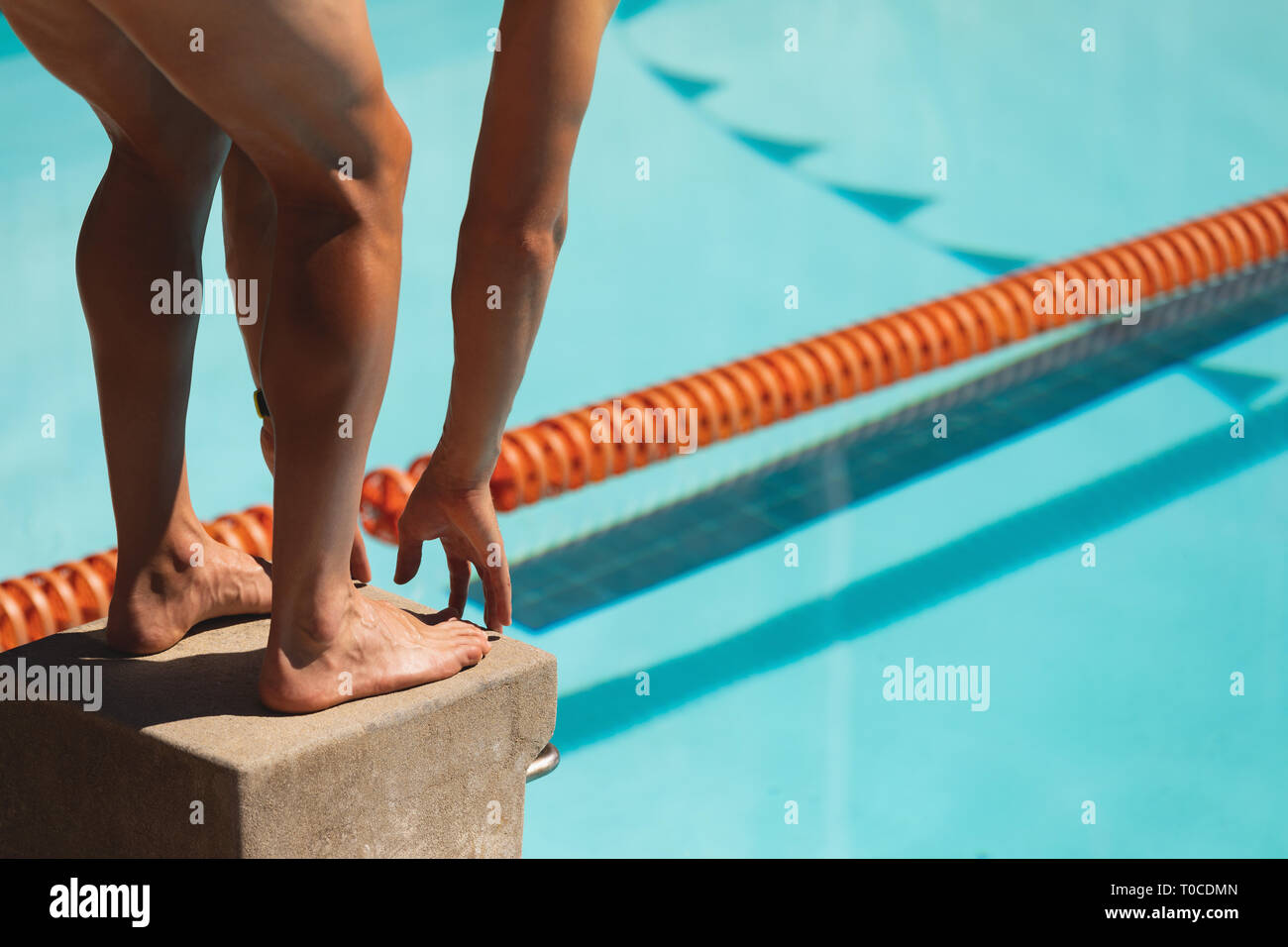 Male swimmer standing on starting block in starting position Stock ...