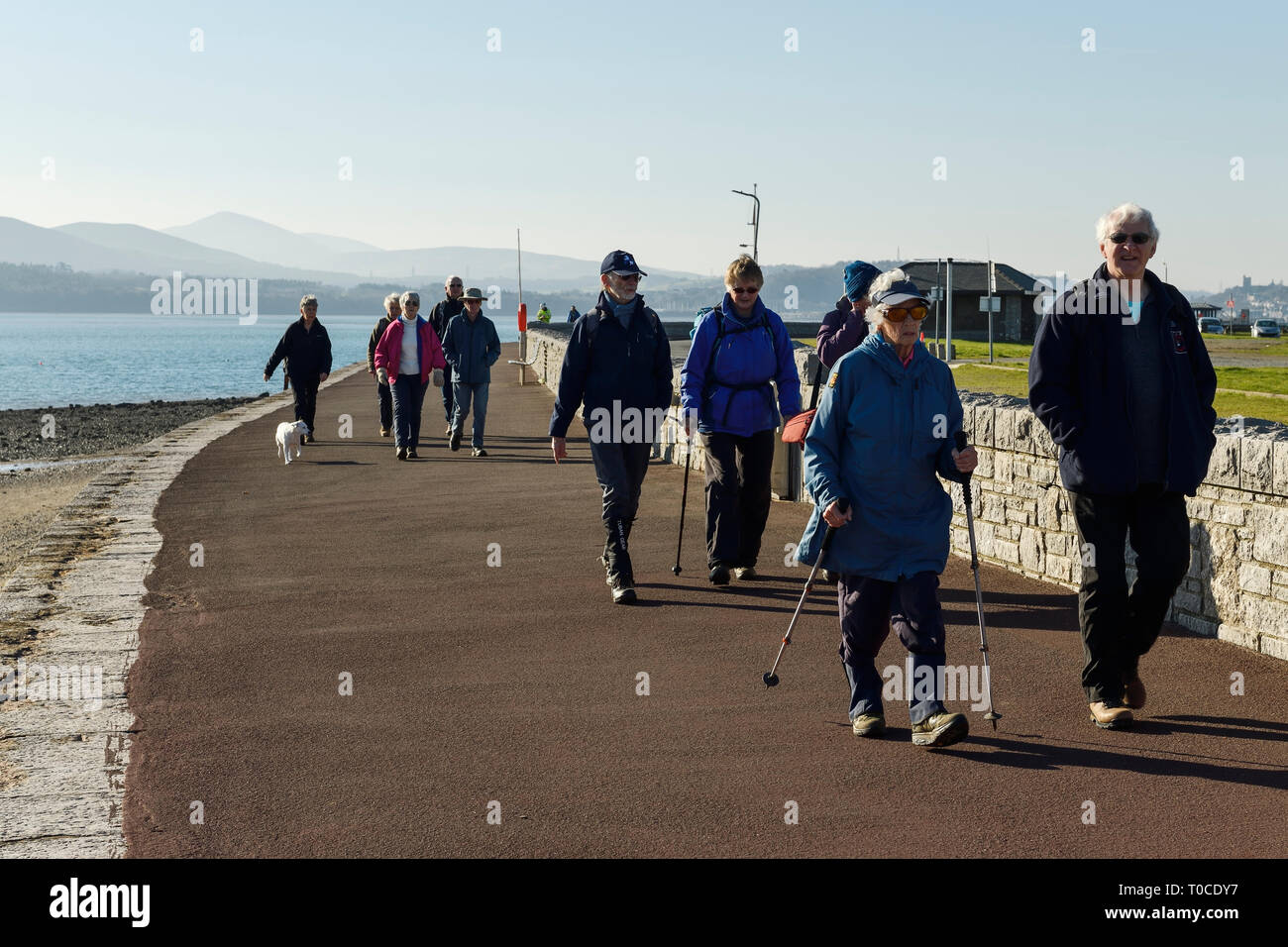 People walking along the seafront in Beaumaris town centre, Anglesey ...