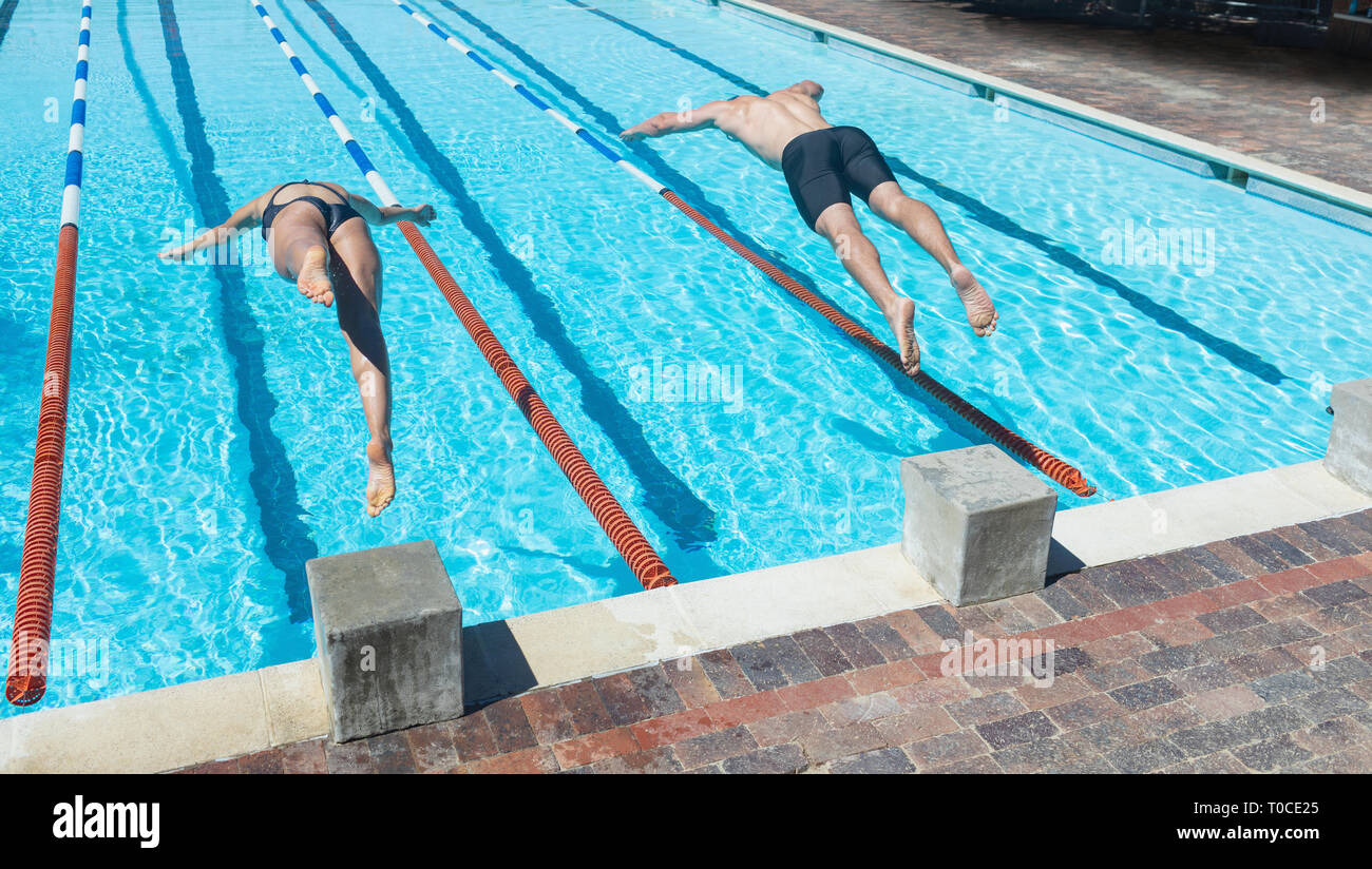 Young swimmers jumping into water at swimming pool Stock Photo - Alamy