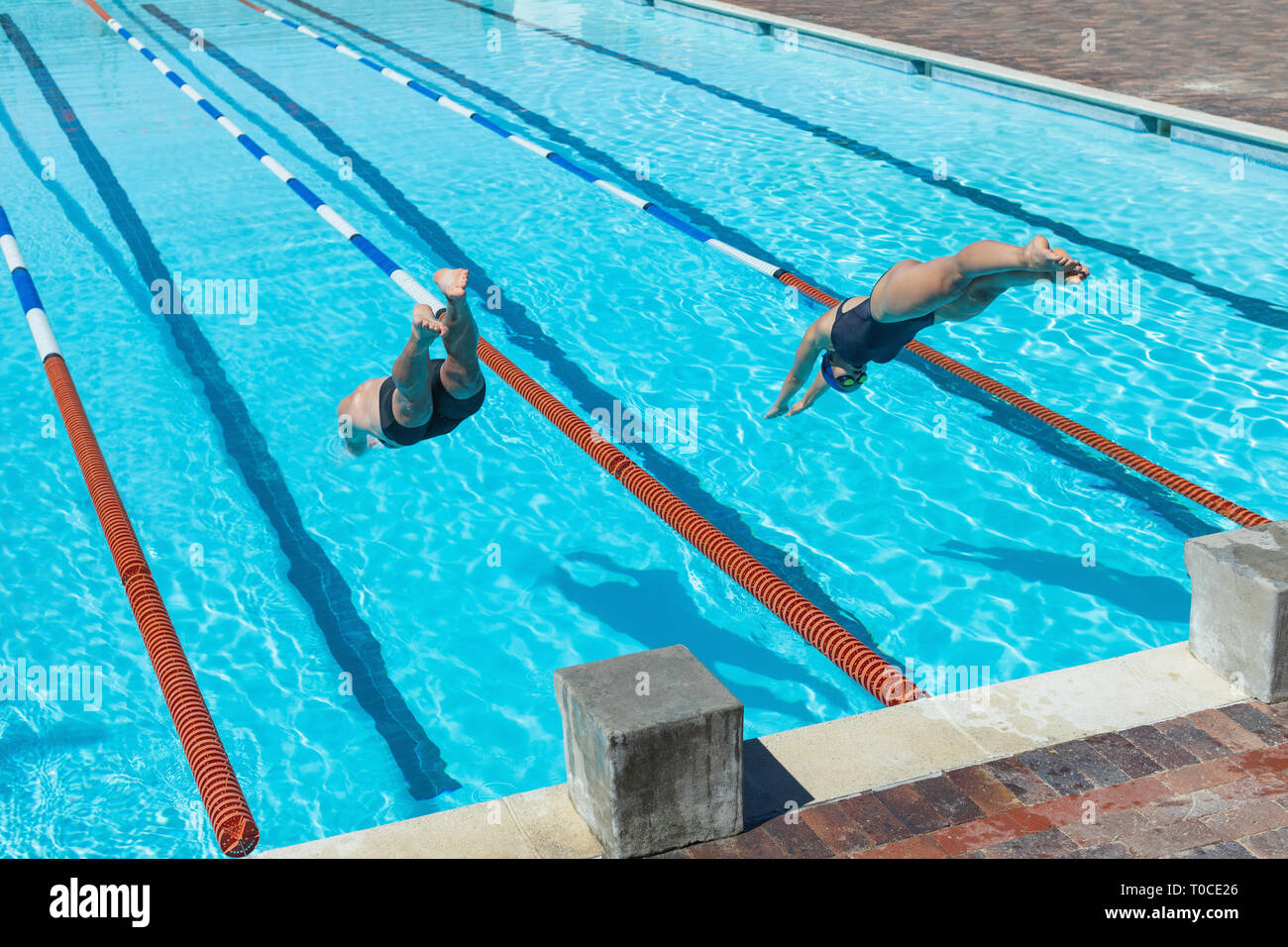Young swimmers jumping into water at swimming pool Stock Photo - Alamy
