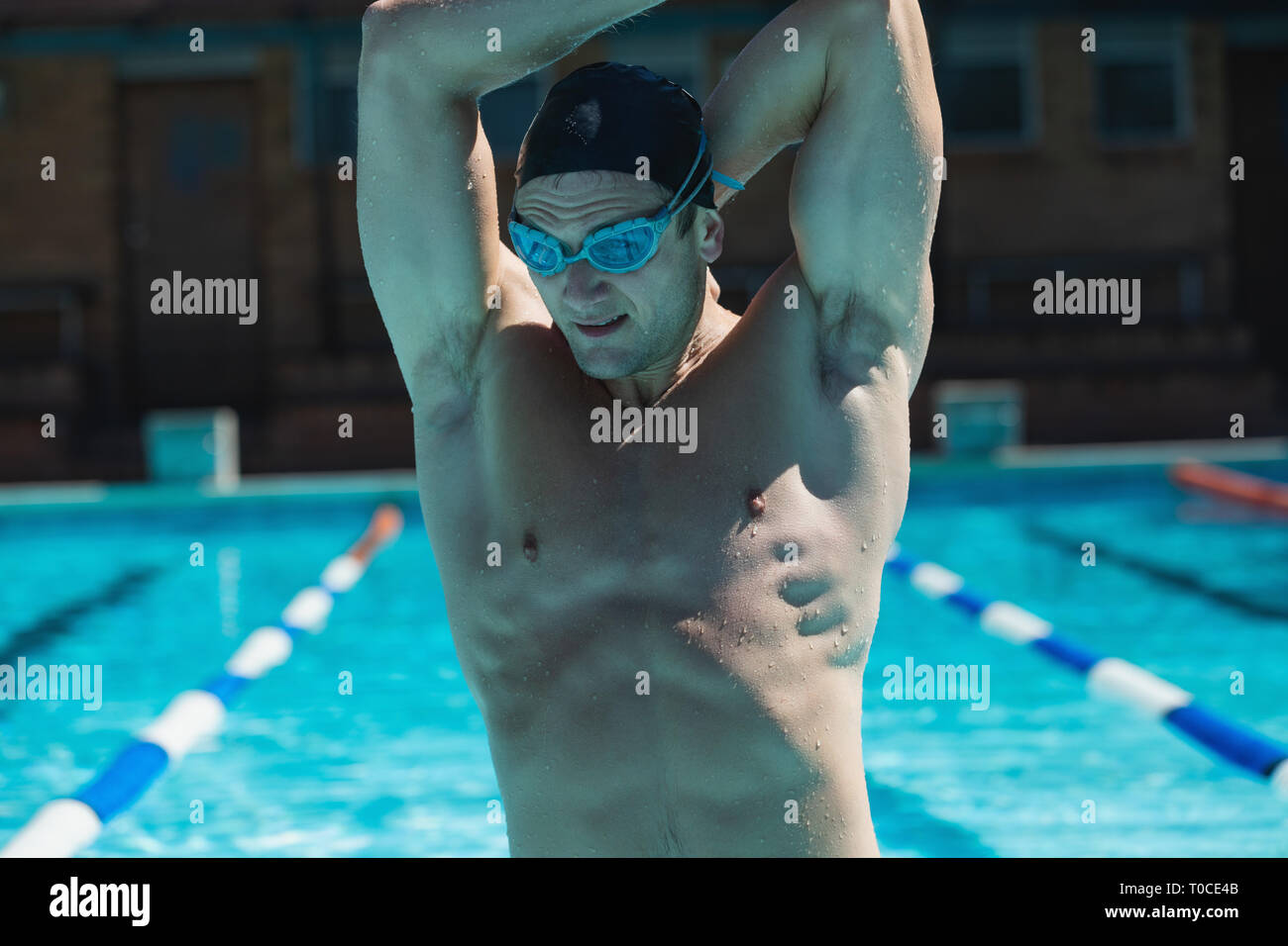 Young man swimmer with swim goggle stretching at swimming pool Stock ...