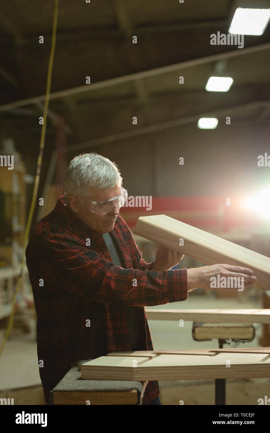 Carpenter taking measurement of wood at workshop Stock Photo - Alamy