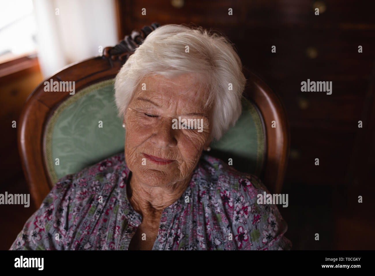 Active senior woman sleeping on chair in living room at home Stock ...