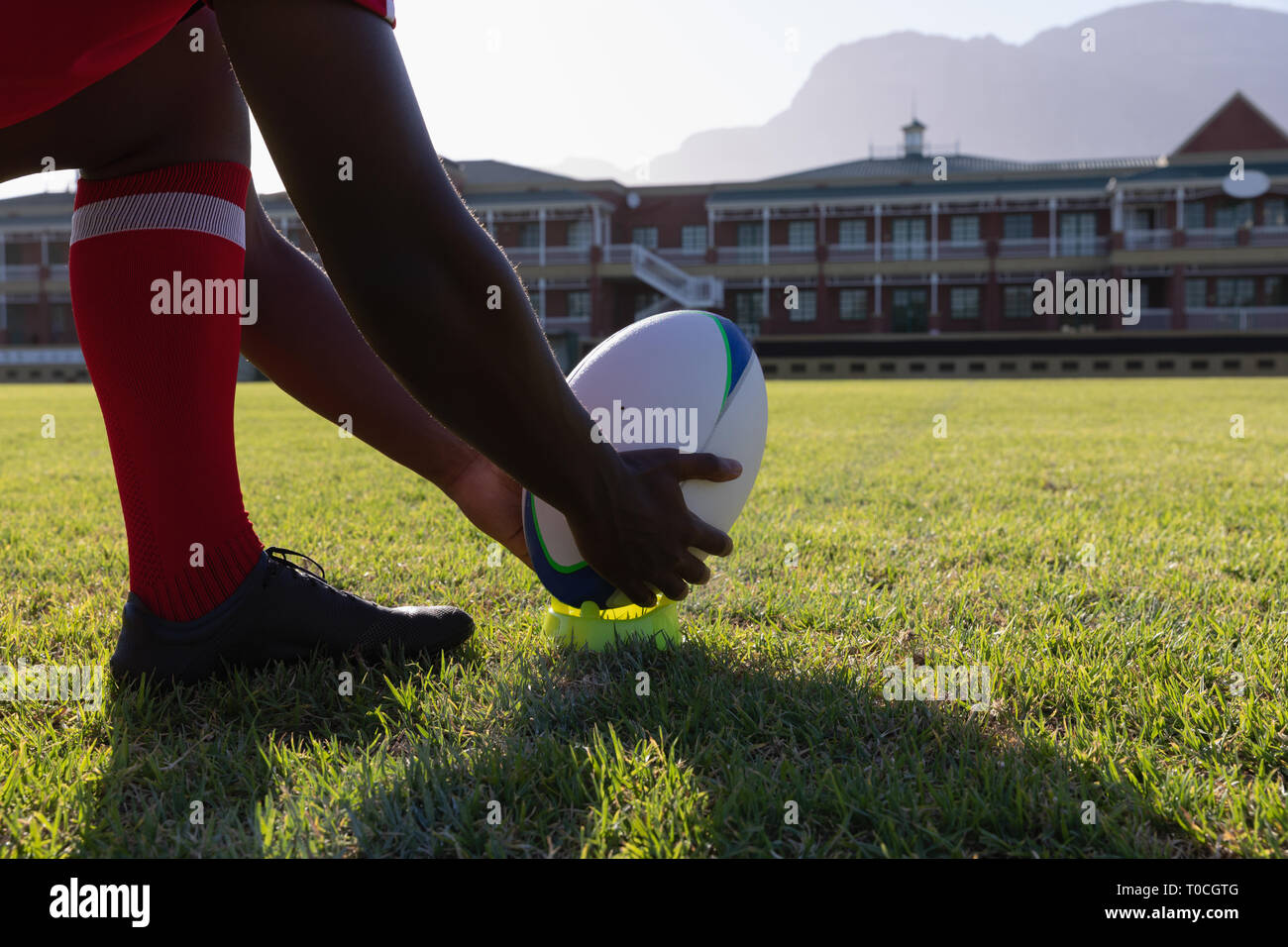 Male rugby player placing rugby ball on a stand in the rugby playground ...