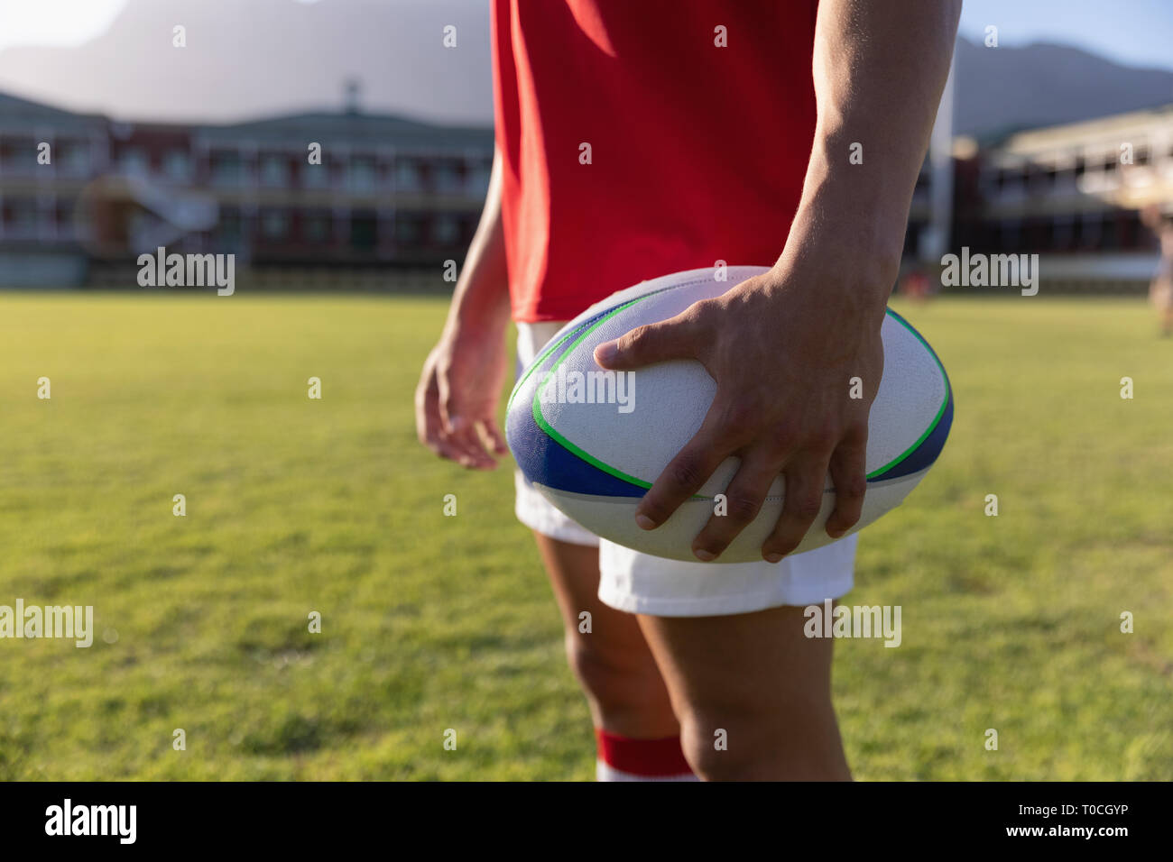 Male rugby player holding rugby ball in the ground Stock Photo - Alamy