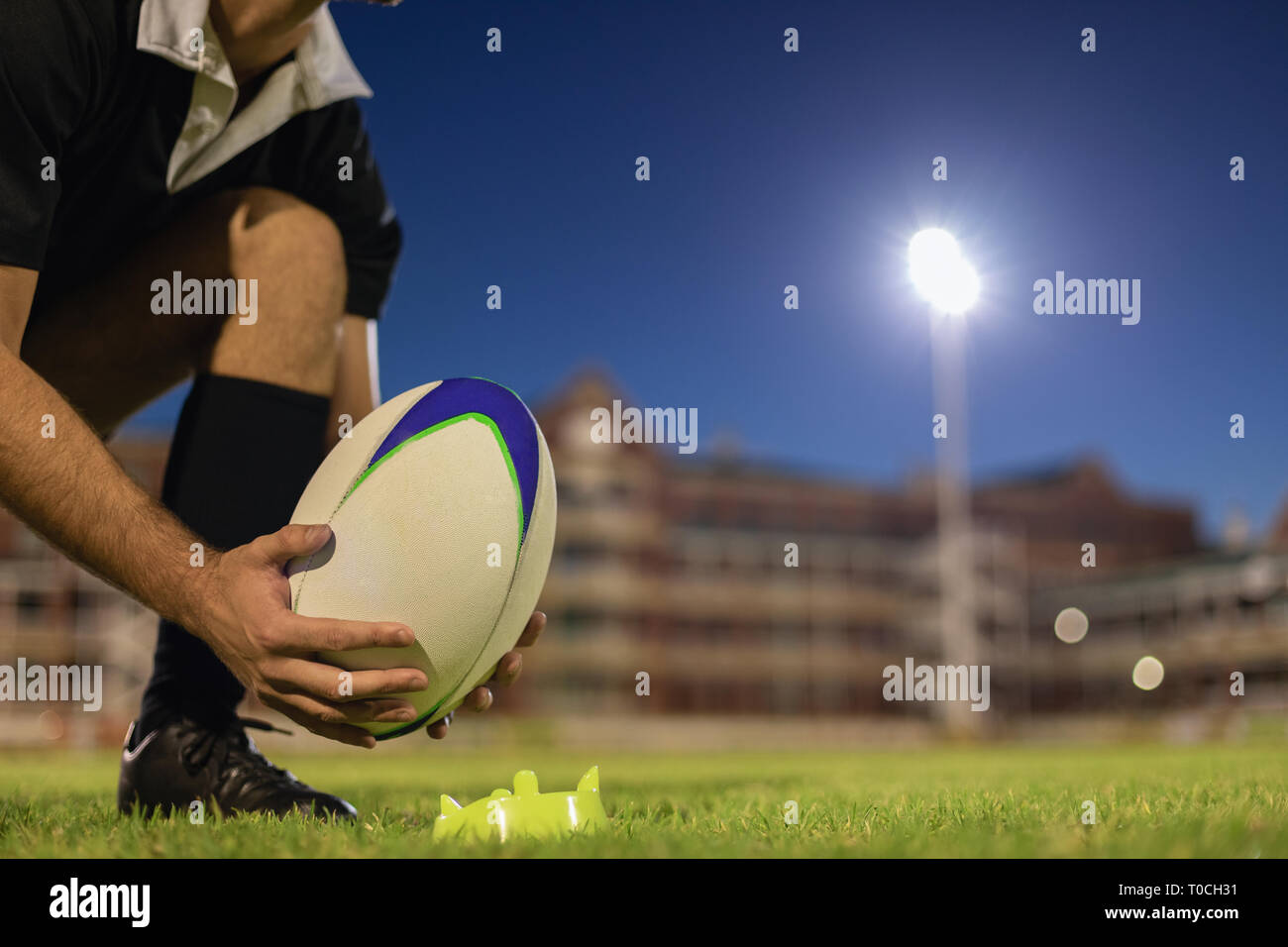 Male rugby player placing rugby ball on a stand in the stadium Stock ...