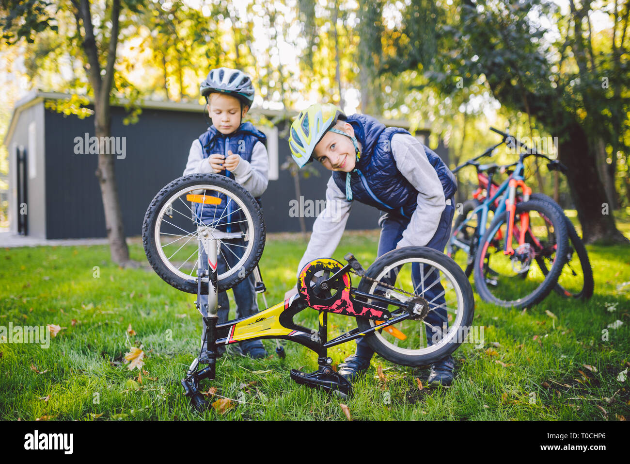 Two children, older boys and younger brother learning repair bike. Two ...
