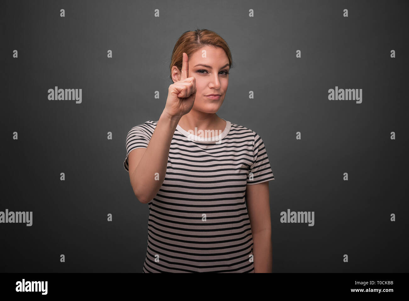 Beautiful smiling blonde woman showing forefinger up. Idea Stock Photo ...