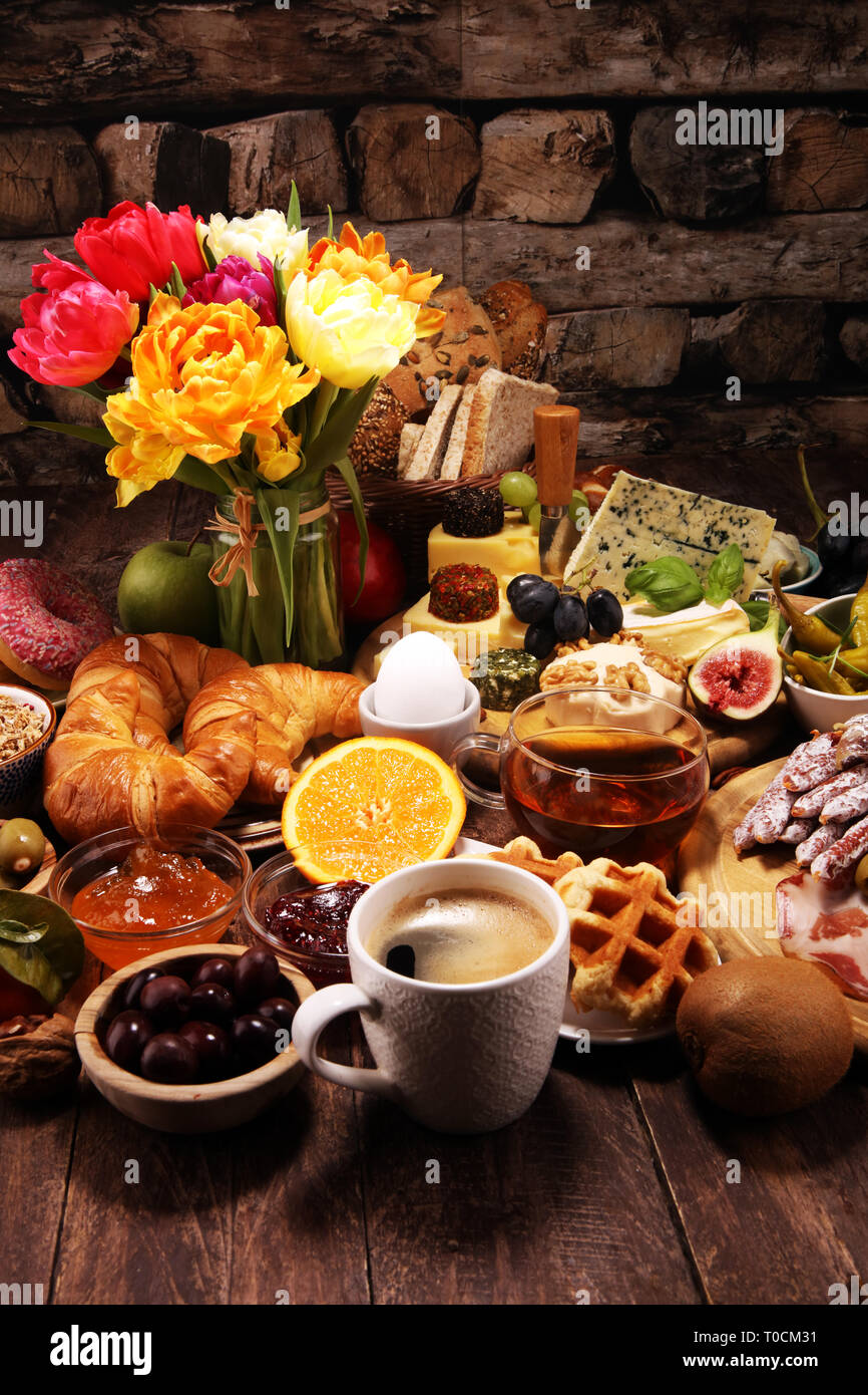 breakfast on table with bread buns, croissants, coffe and donuts Stock ...