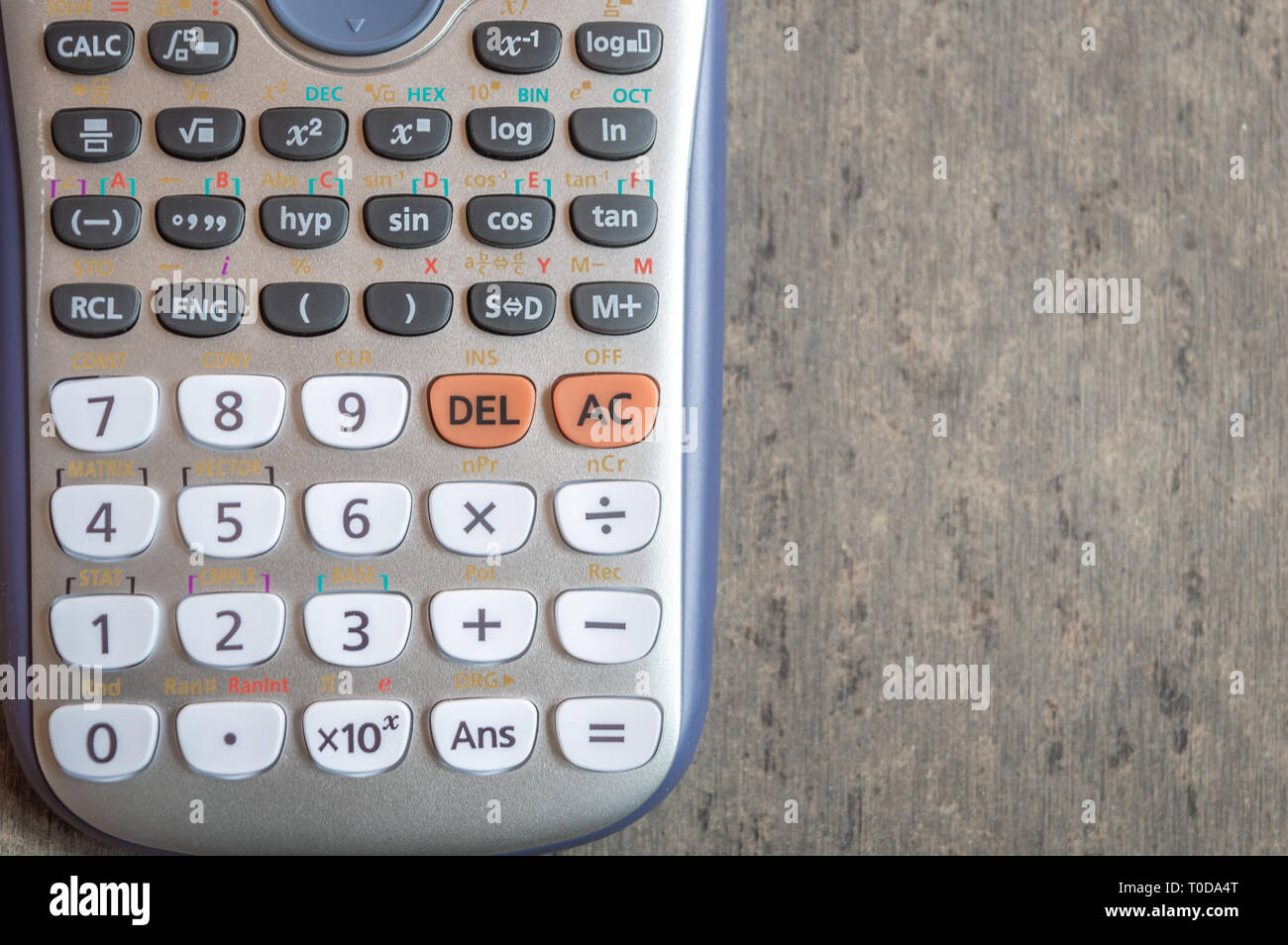 A white scientific calculator kept on a table with copy space for ...