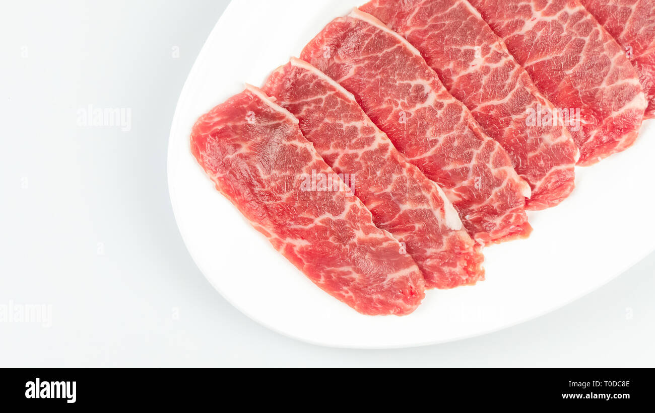 Top view of some raw beef on a plate over white background Stock Photo ...