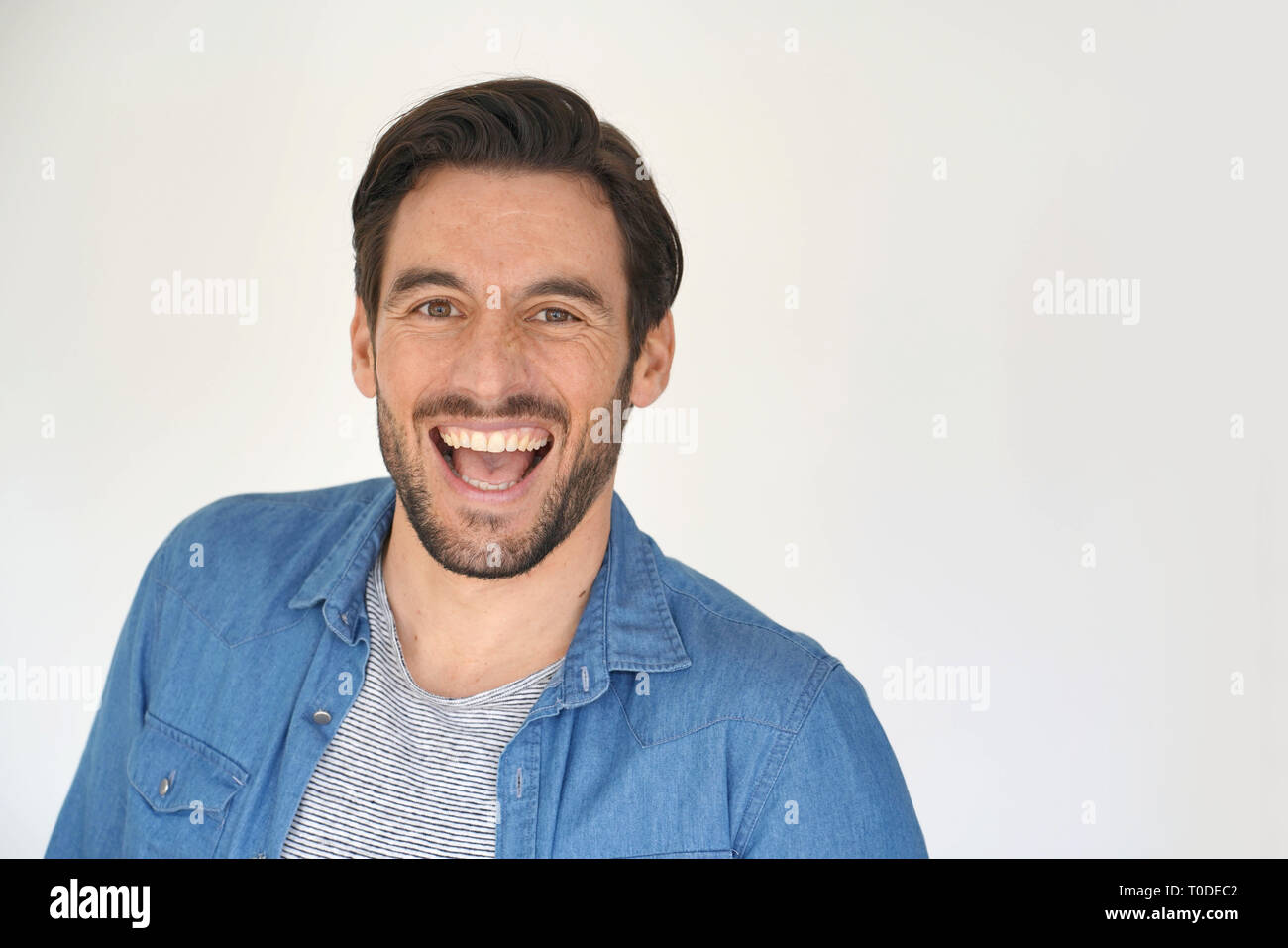 Portrait of casual laughing handsome man on white background Stock ...
