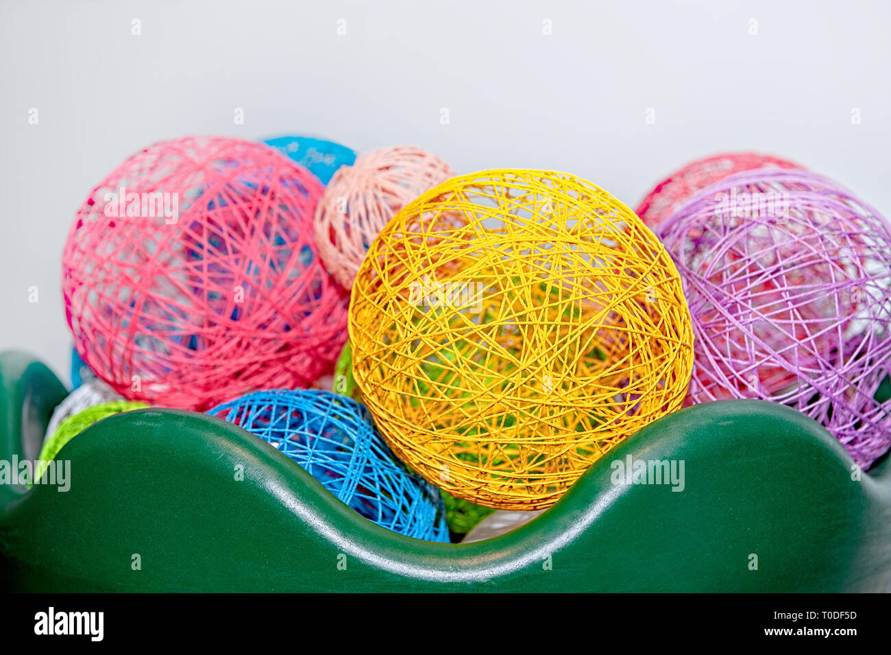 Multicolored balls of threads in a green vase. Interior decoration ...