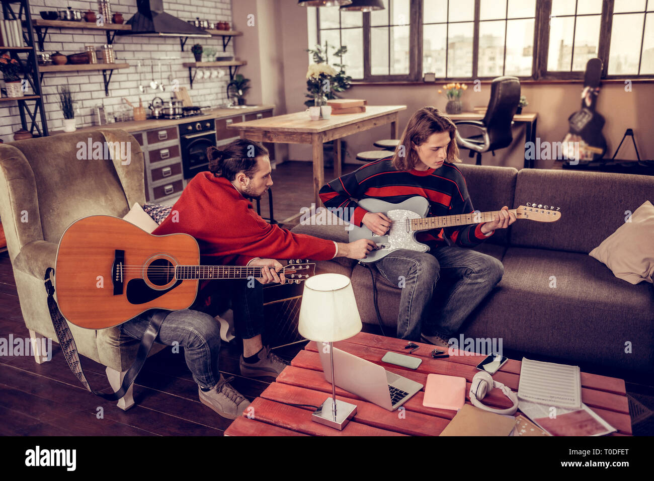 Two musicians watching music video and making their own cover Stock ...