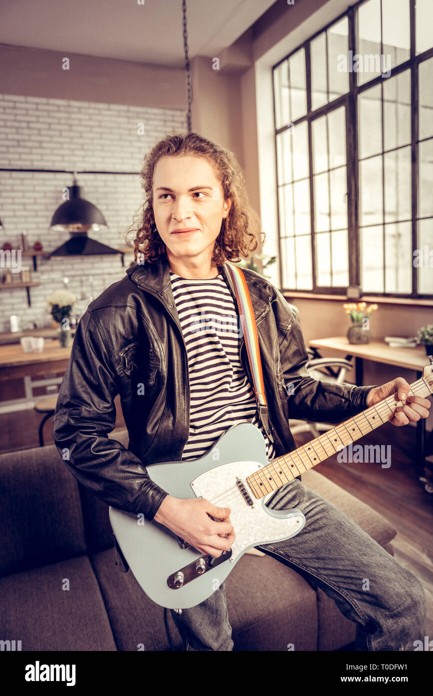 Dark-eyed rock musician wearing leather jacket feeling happy Stock ...