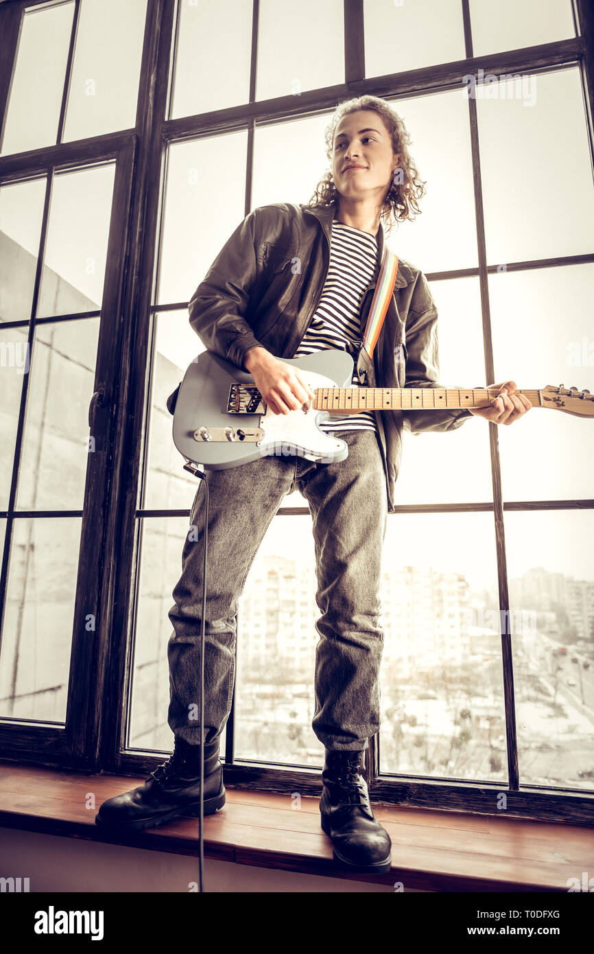 Curly musician feeling good after composing new melody Stock Photo - Alamy