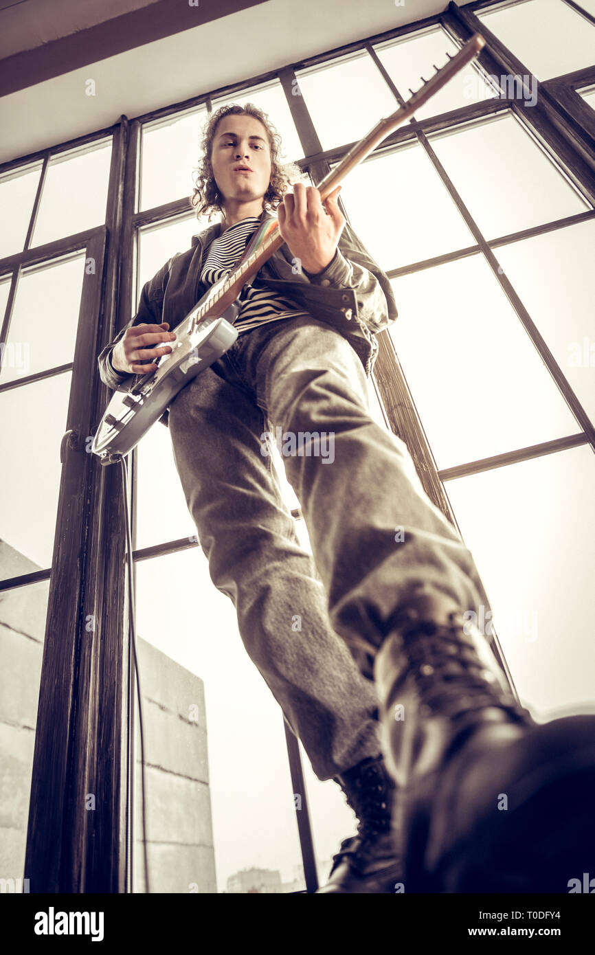 Rock musician wearing massive leather boots playing music Stock Photo ...