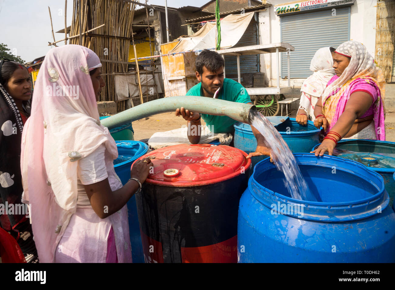 People filling water in plastic drums from water tanker, water shortage ...