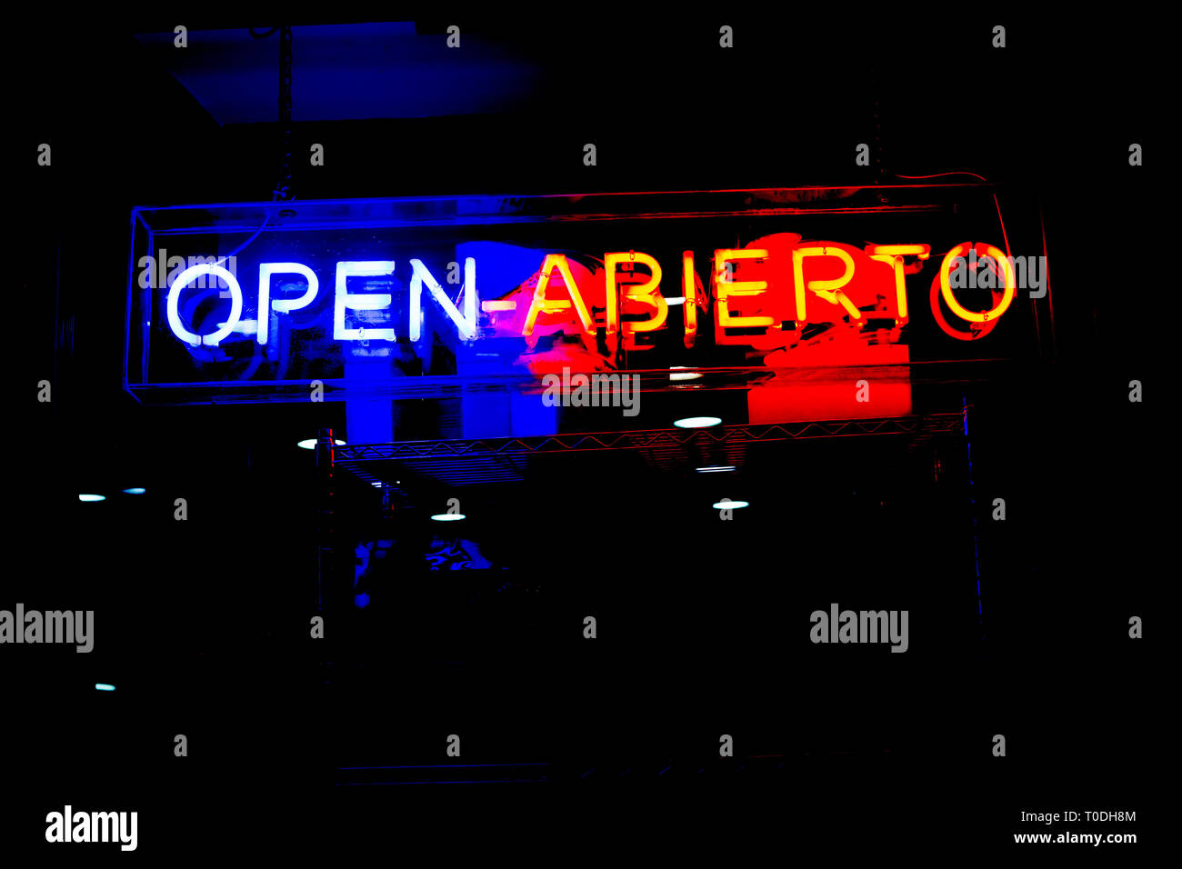 Neon shop "Open" (In Spanish and English) store sign at night in street ...