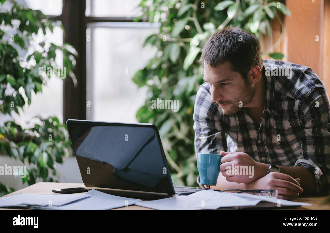 Young business man work on computer in his pleasant studio home office ...