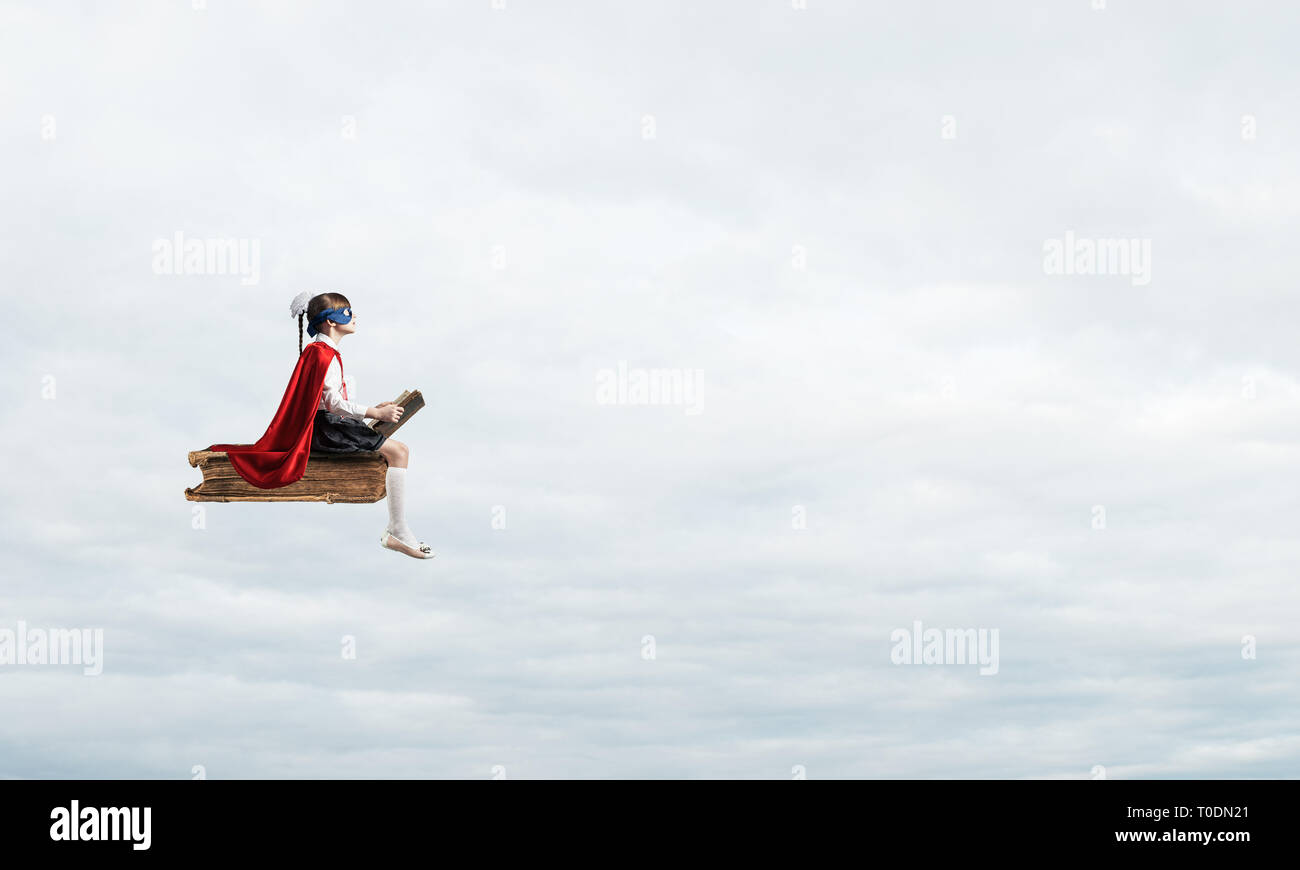 Girl power concept with cute kid guardian against cloudscape background ...