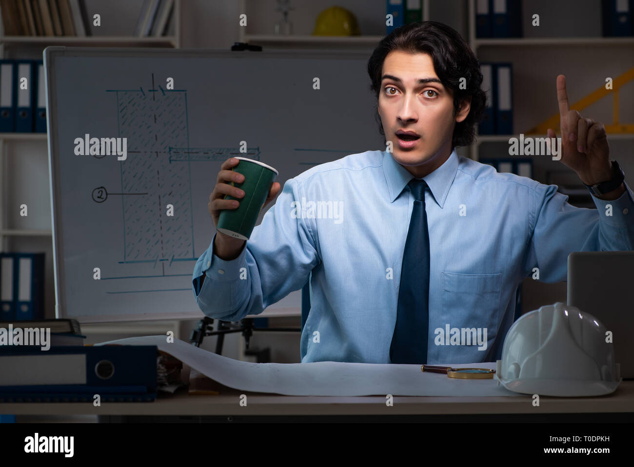 Young male architect working night at office Stock Photo - Alamy