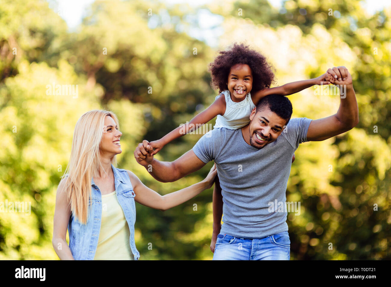 Picture of happy young couple spending time with their daughter Stock ...