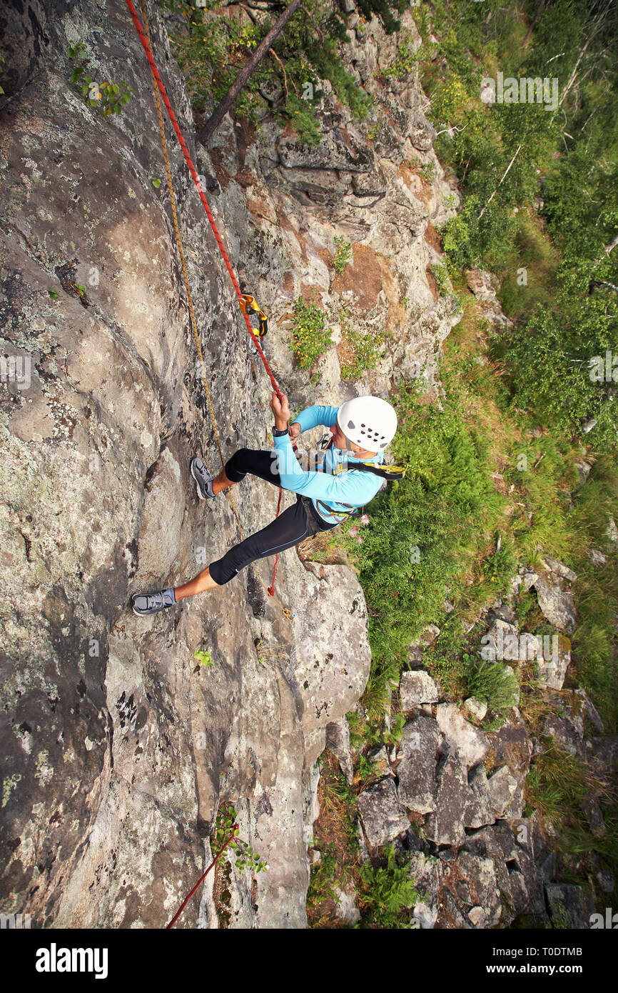 climber in helmet overcomes rocky wall with a rope insurance Stock ...