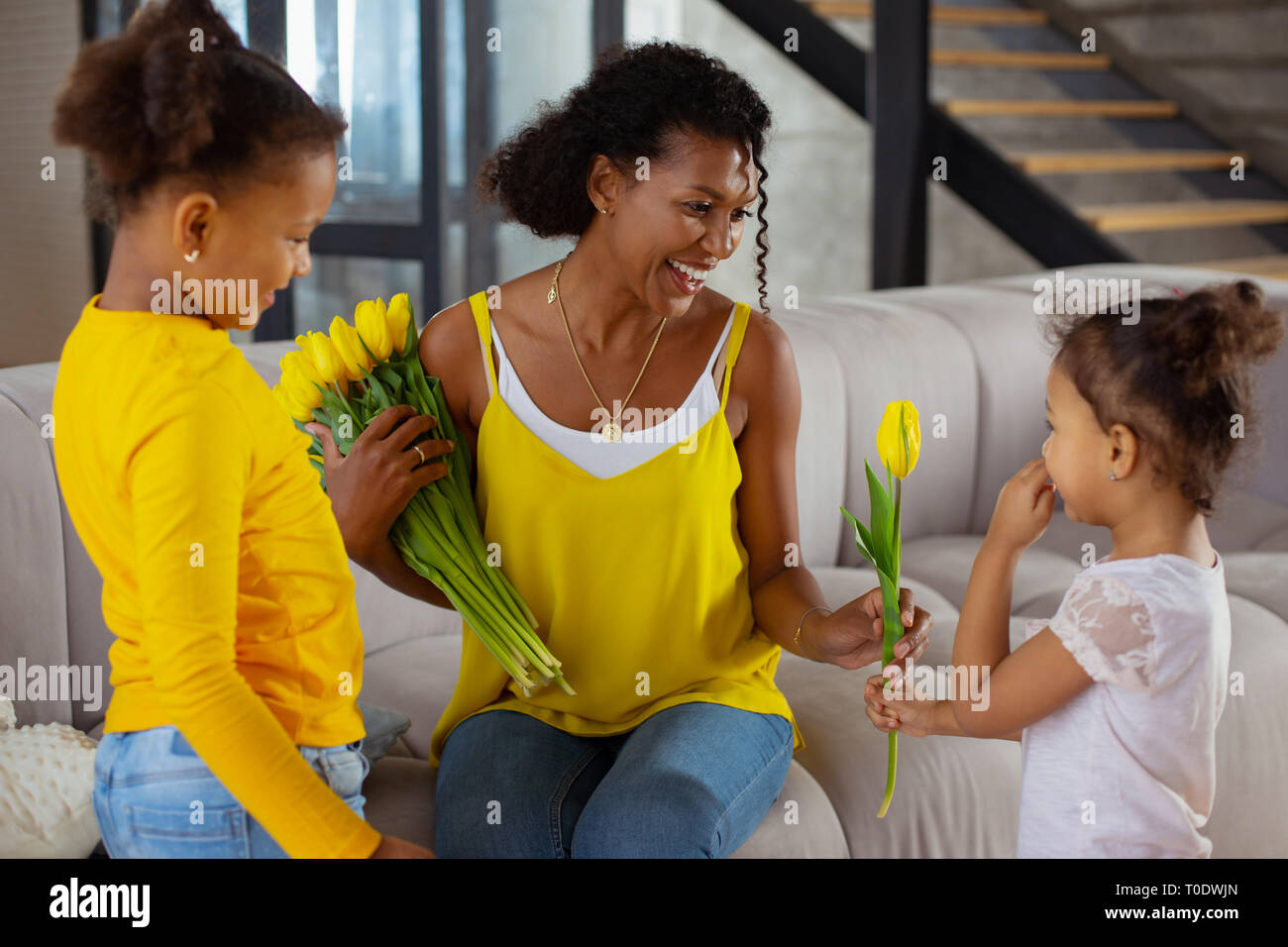 International mommy presenting flowers to her children Stock Photo - Alamy