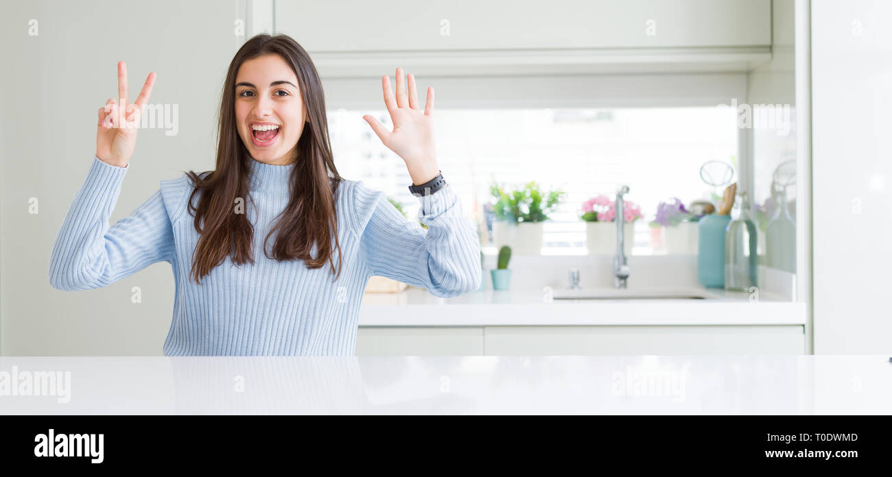 Wide angle picture of beautiful young woman sitting on white table at ...